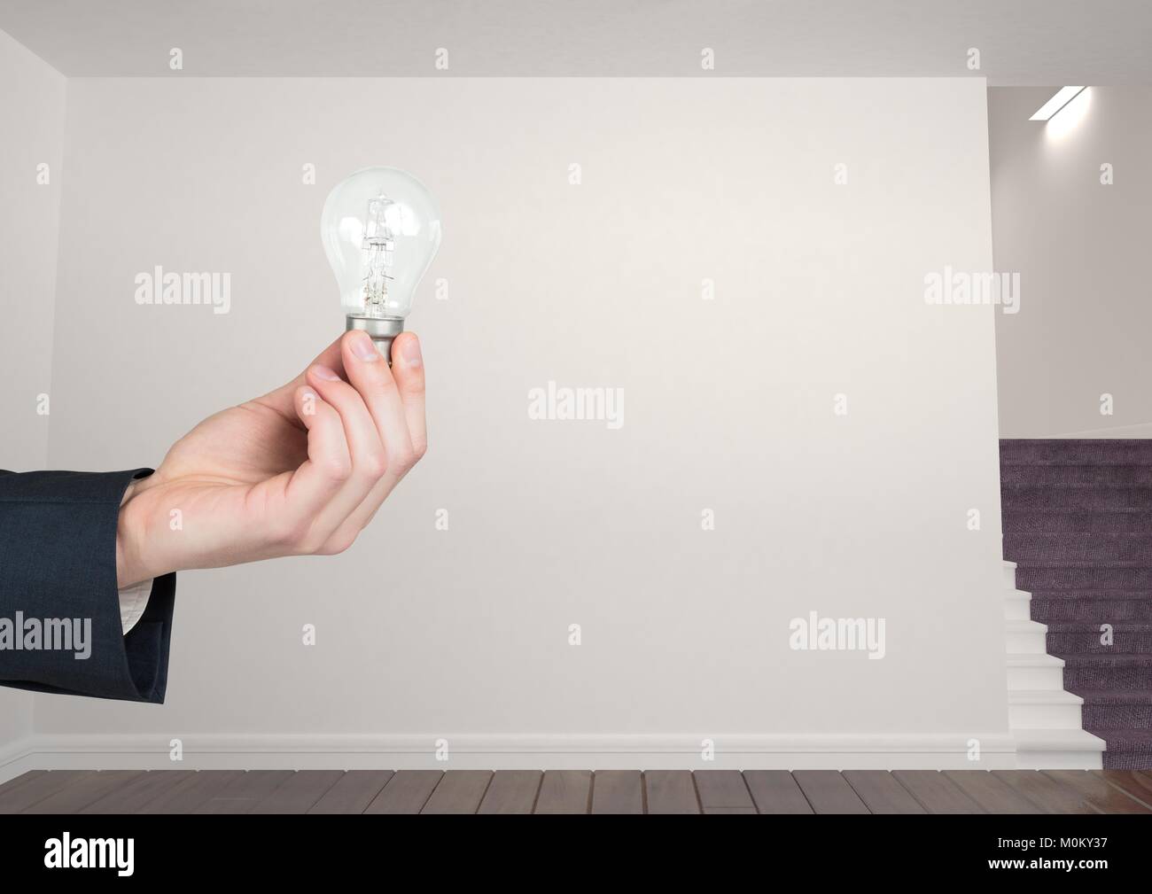 Hand holding light bulb in room Stock Photo - Alamy