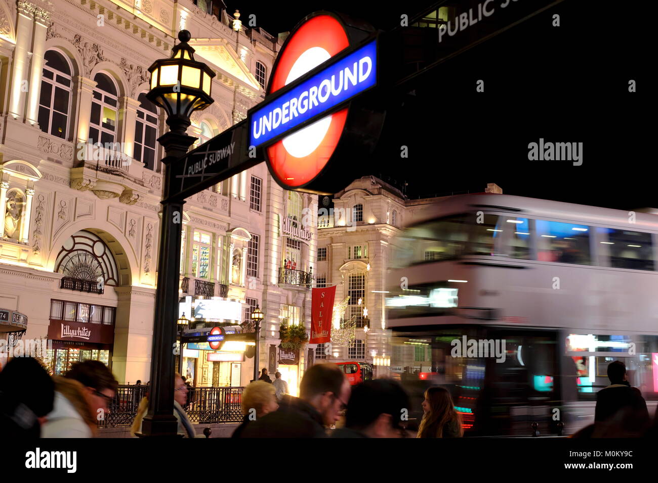 lluminated Underground sign on a busy London street at night Stock ...