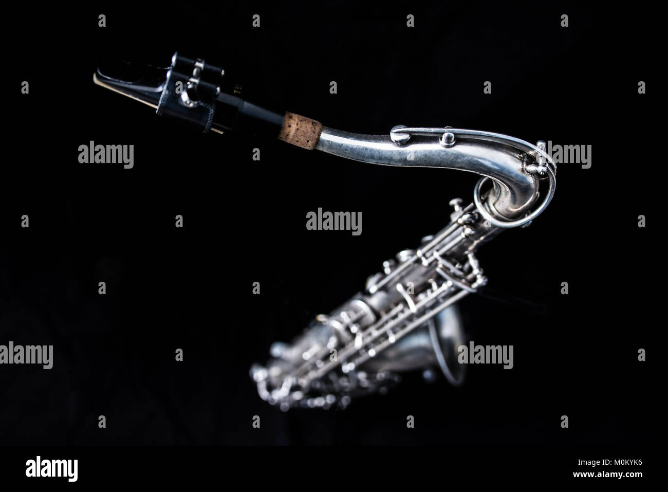 Full view of a silver saxophone standing isolated in black Stock Photo ...
