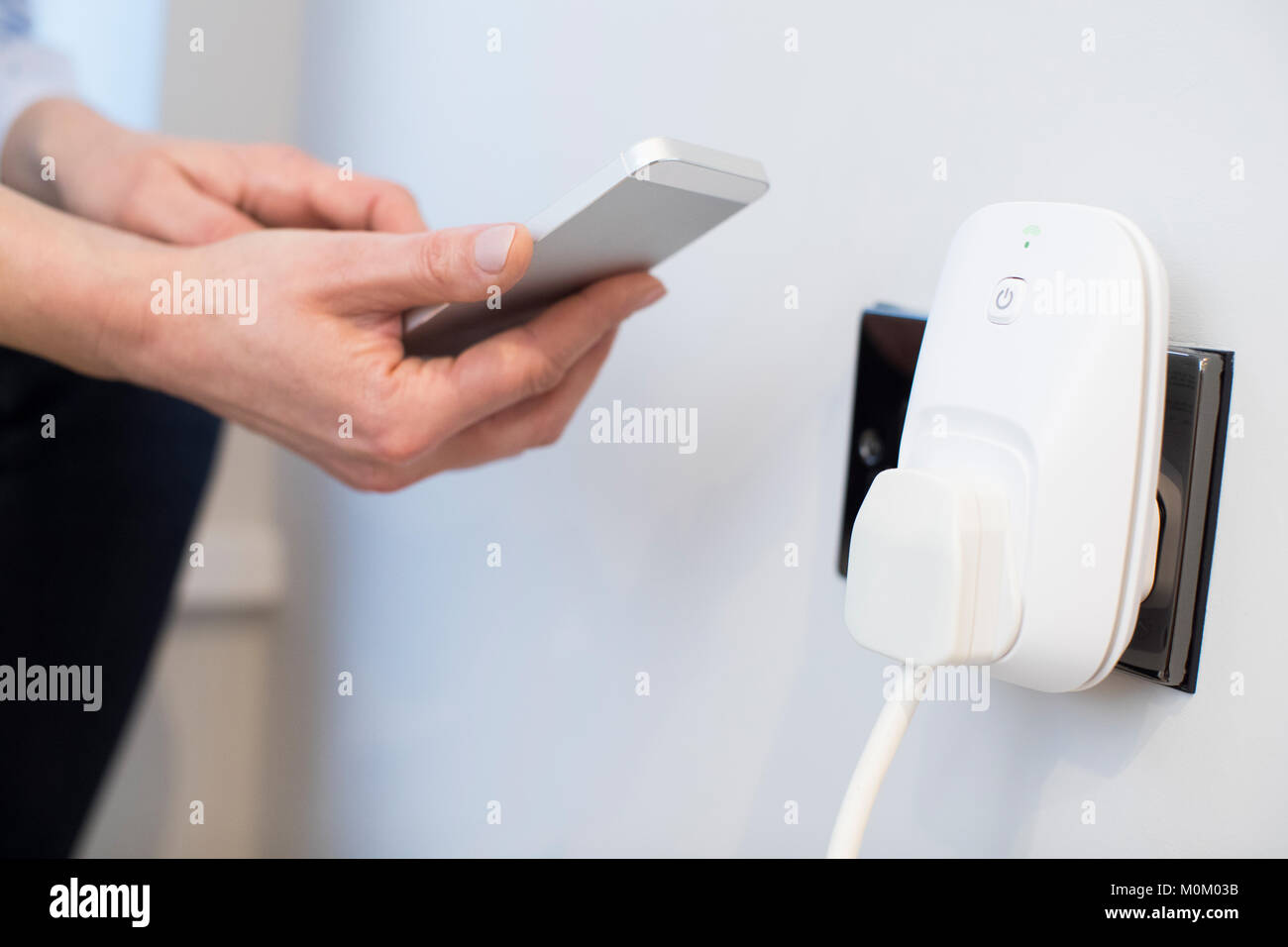Woman Controlling Smart Plug Using App On Mobile Phone Stock Photo - Alamy