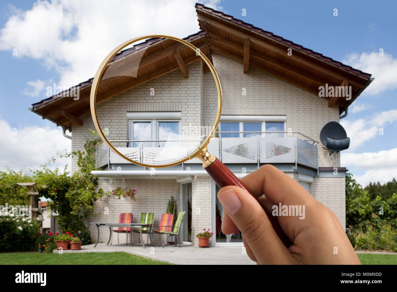 Close-up Of Person's Hand Holding Magnifying Glass Over Luxury House ...