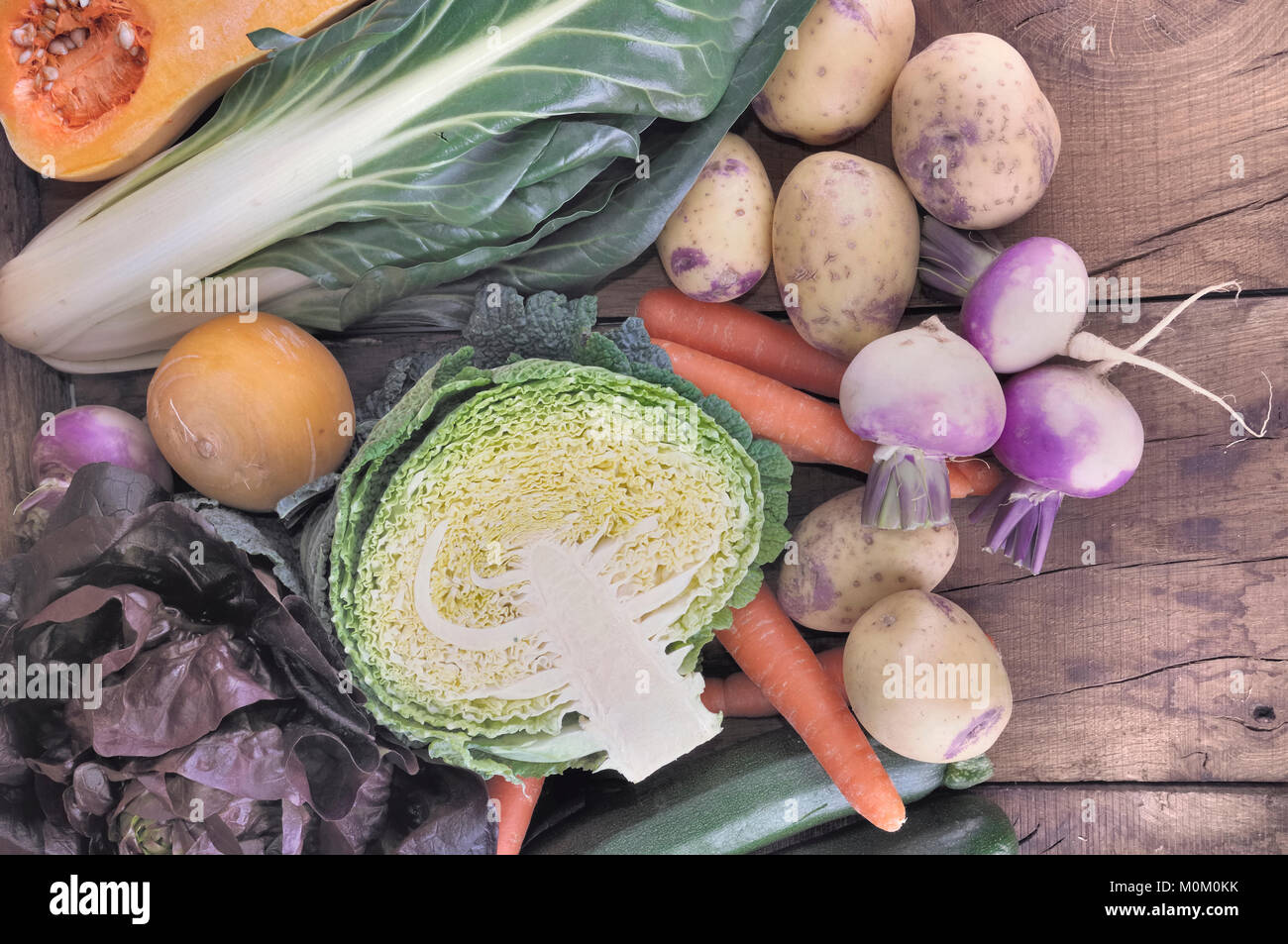 top view on half of the green cabbage and other seasonal vegetables on ...
