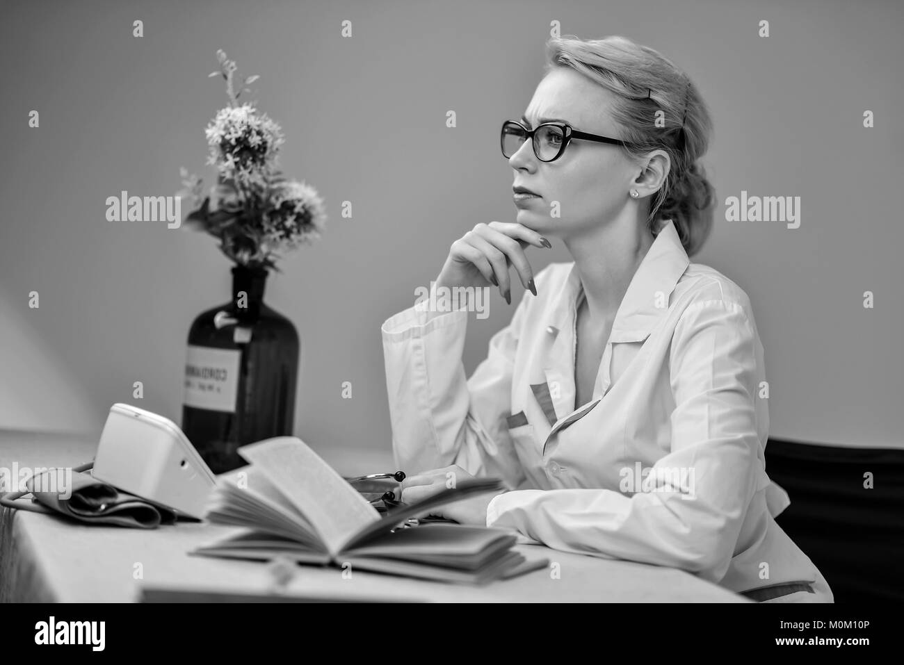 The doctor sitting behind the Desk in his office black and white poster ...