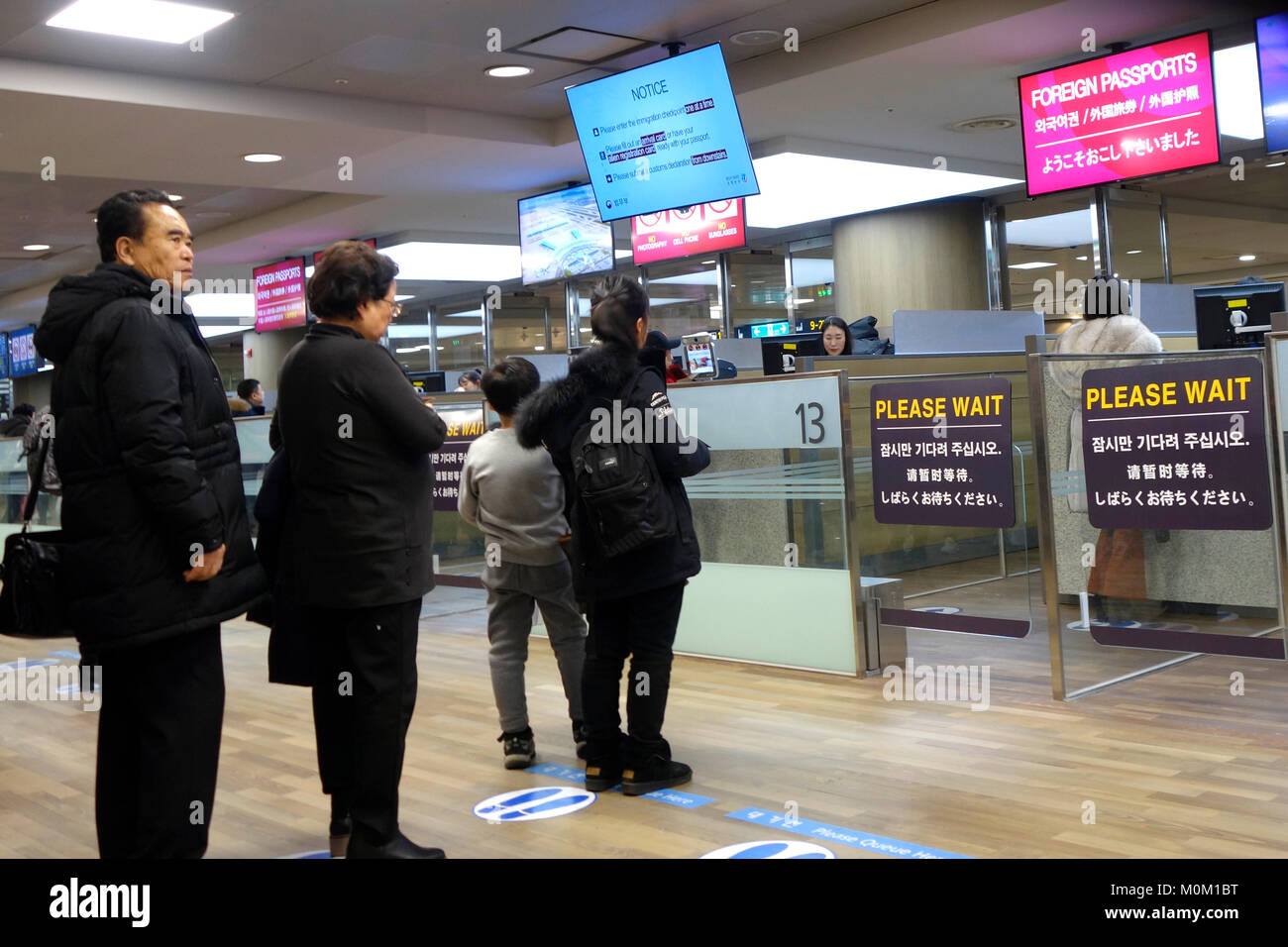 Passengers wait in line for passport control at the arrival hall of ...