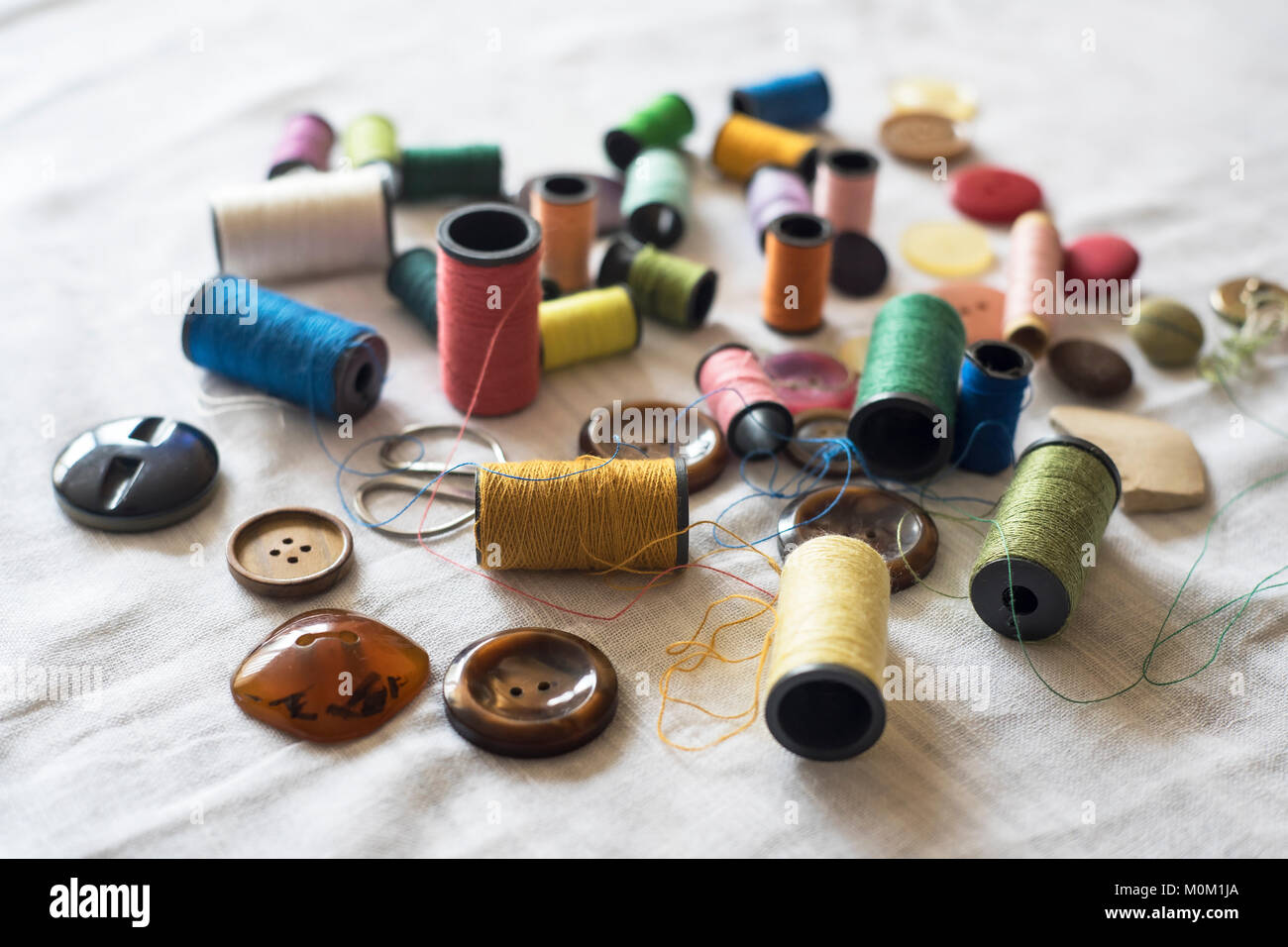 Sewing supplies on a white fabric, close up Stock Photo - Alamy
