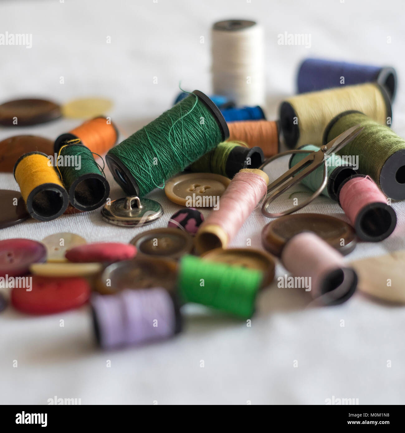 Sewing supplies on a white fabric, close up Stock Photo - Alamy