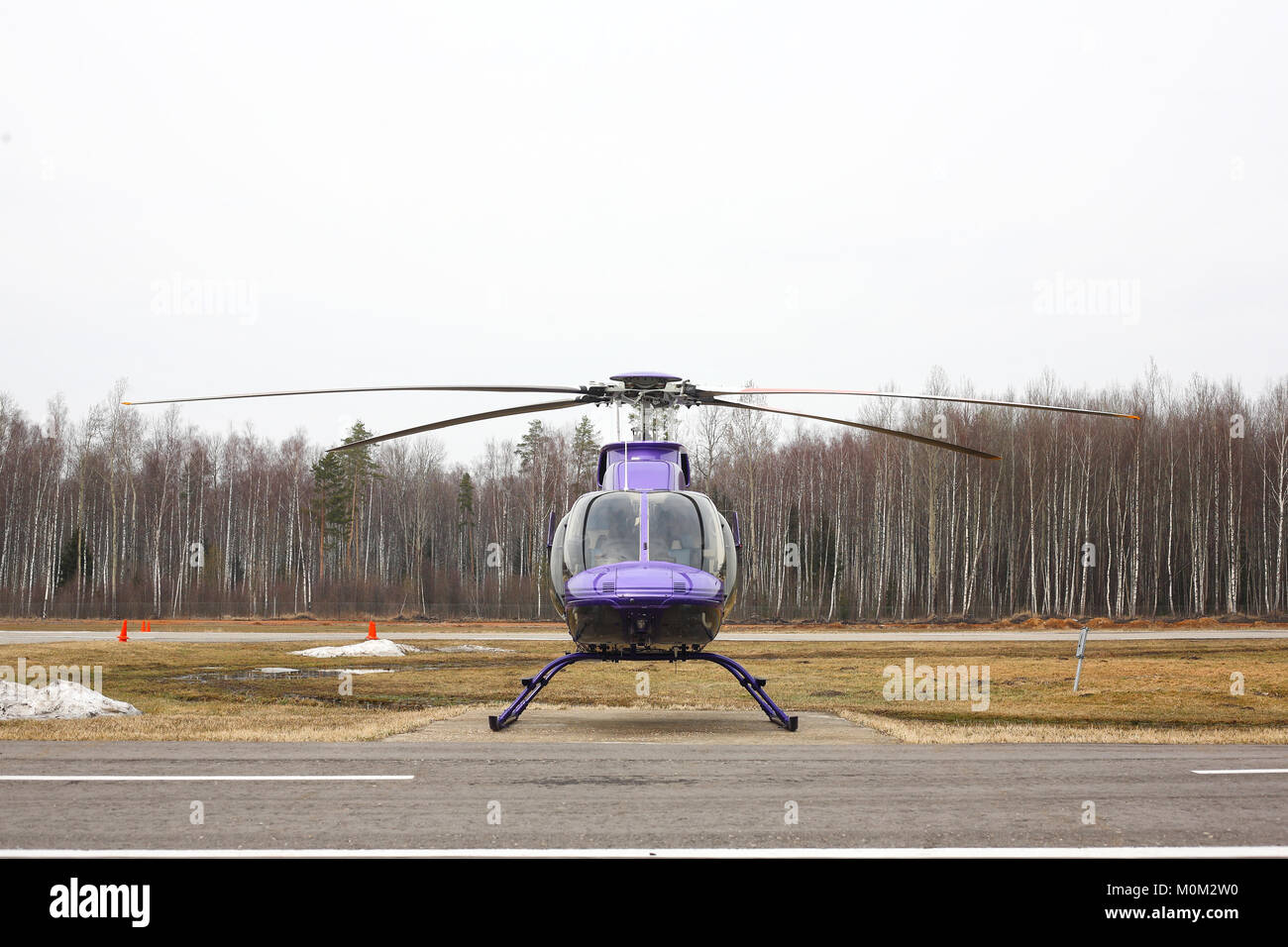 Aircraft - Blue helicopter front view on the parking against the wood ...