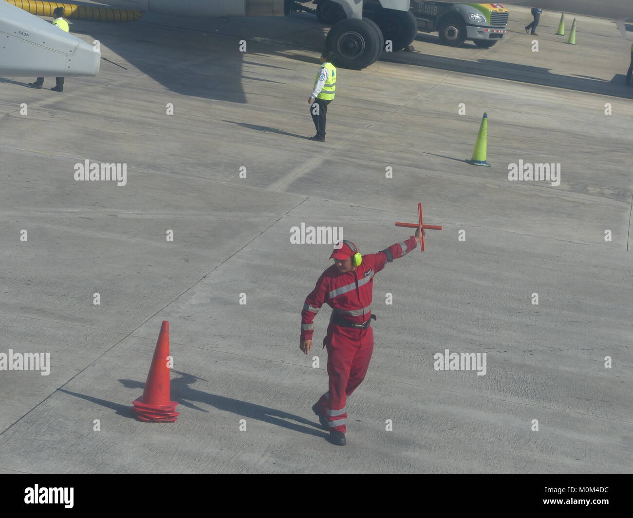 Airport employee directing aircraft to final position Stock Photo - Alamy