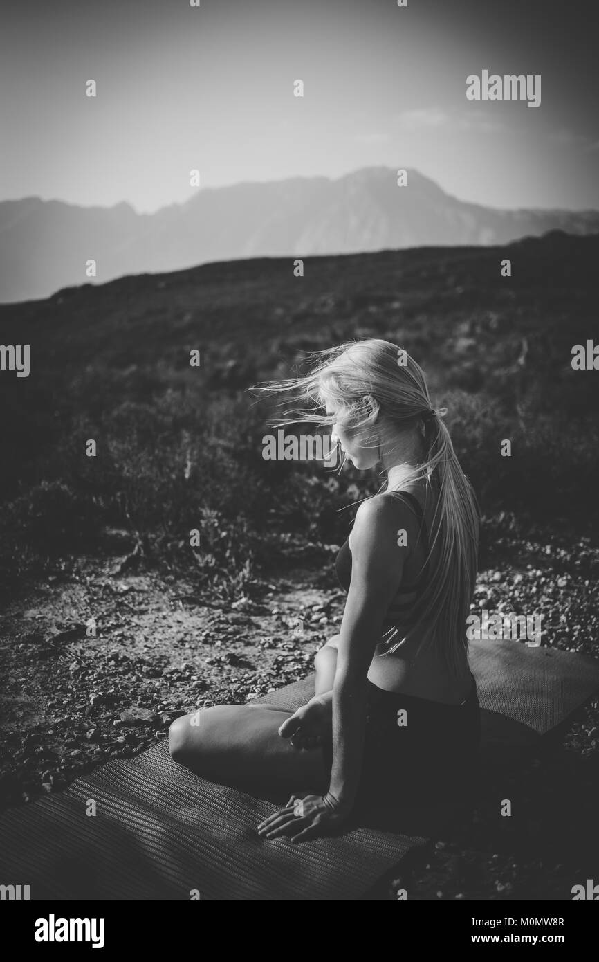 Female model practicing yoga in the outdoors doing stretching and ...