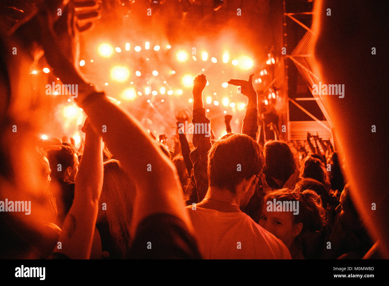 Energetic festival goers and music fans go crazy at a live concert with ...