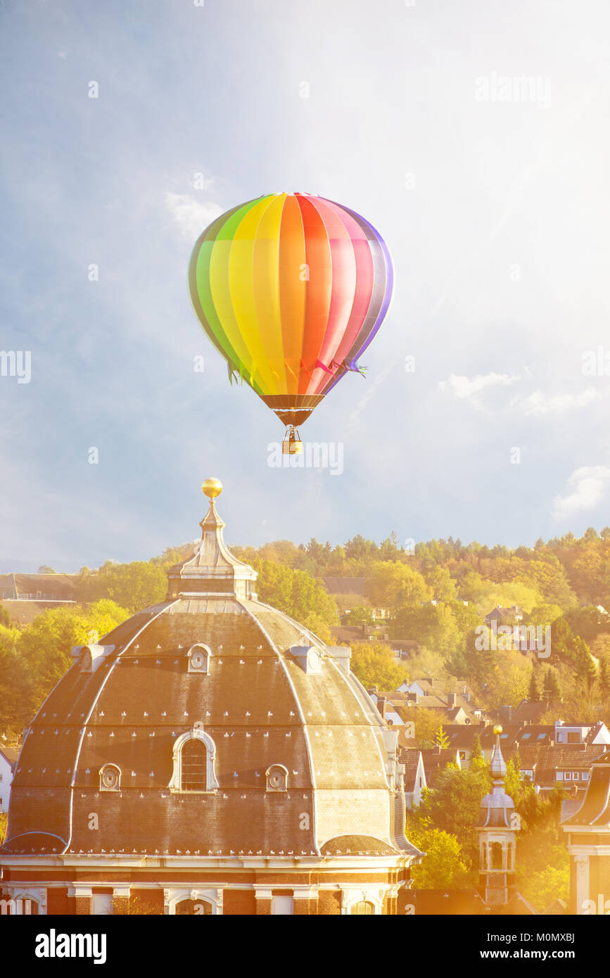 Colorful hot-air balloon flying high up in summer across beautiful ...
