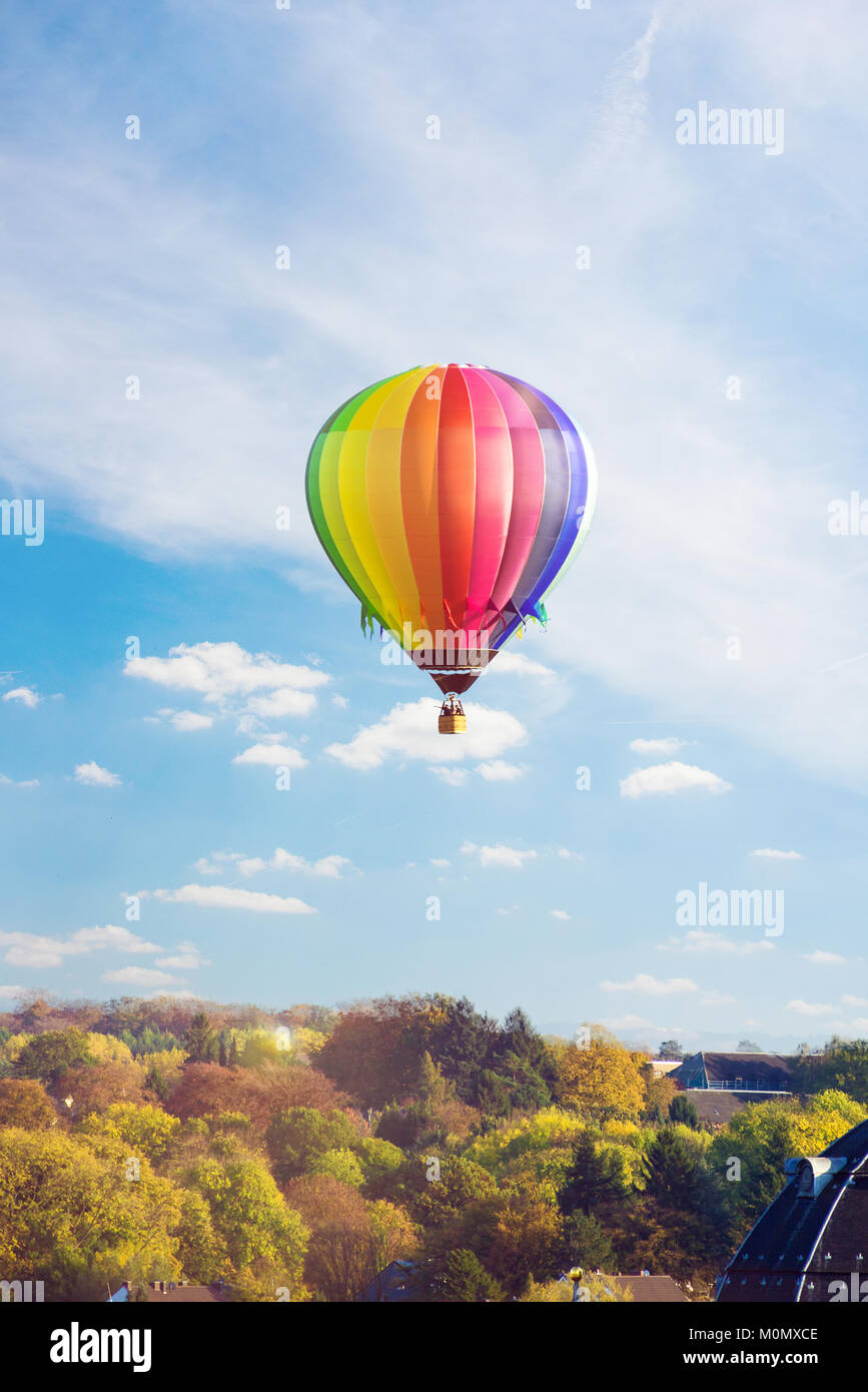 Colorful hot-air balloon flying high up in summer across beautiful ...