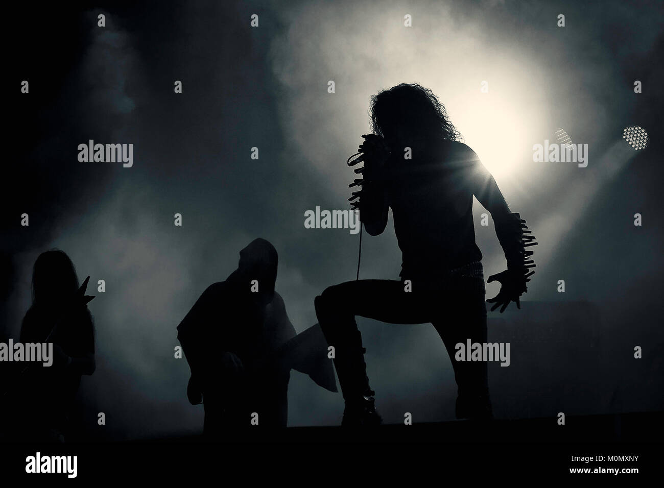 A heavy metal singer and musician pictured in silhouette live on stage ...