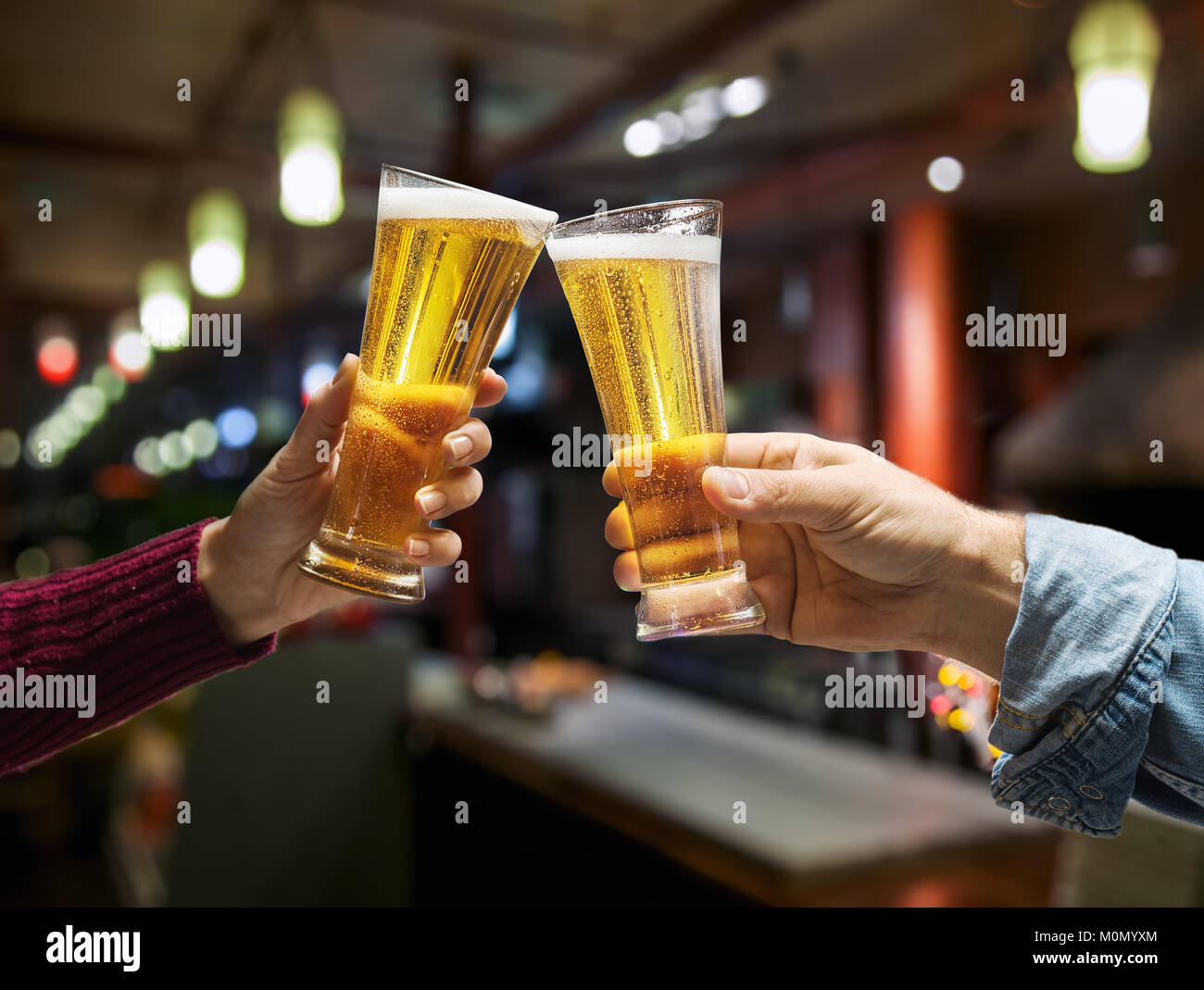 Beer glasses raised in a toast. Close-up hands with glasses. Blurred ...