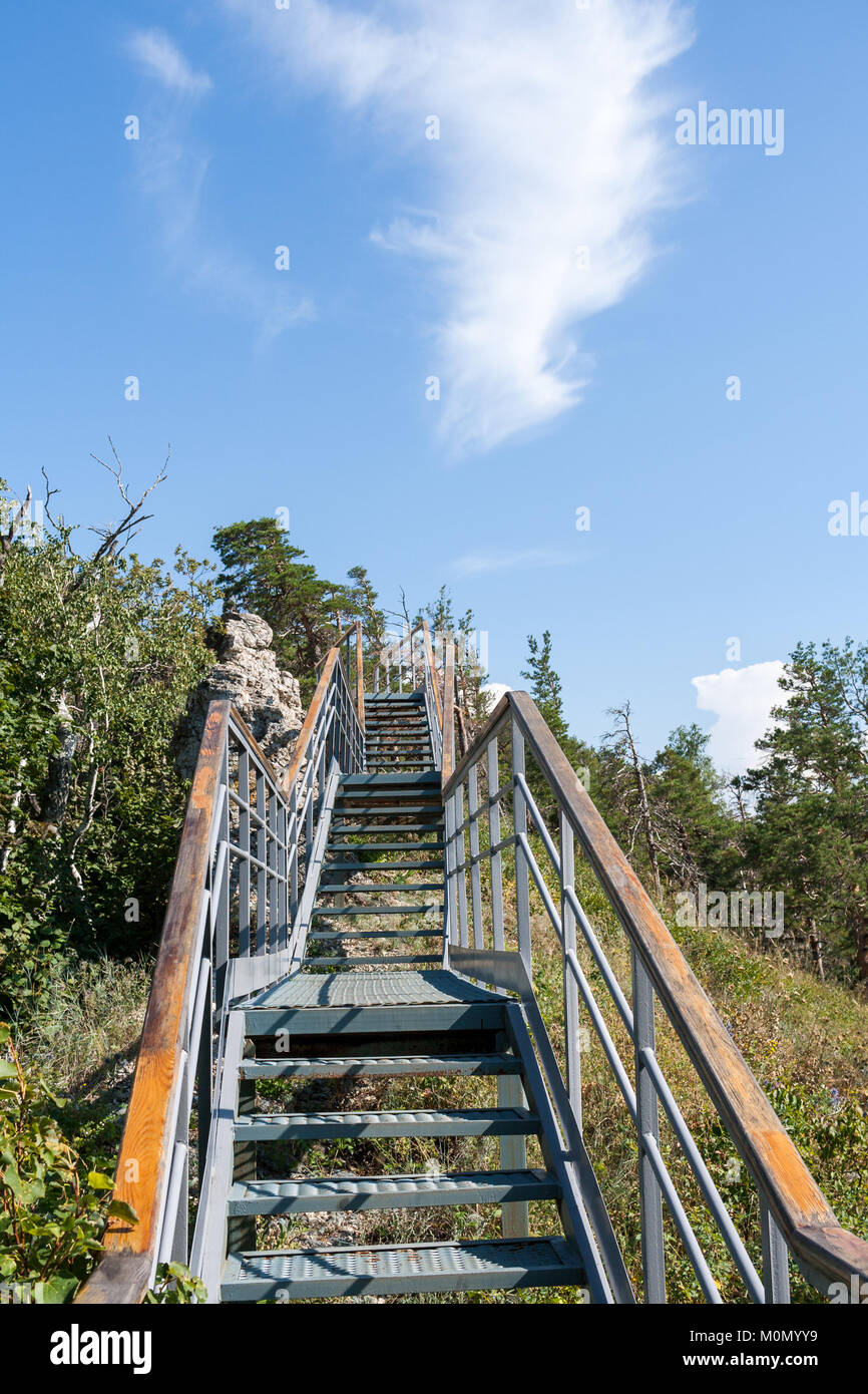 Equipped and fenced walking path, leading to mountain top, and blue sky ...