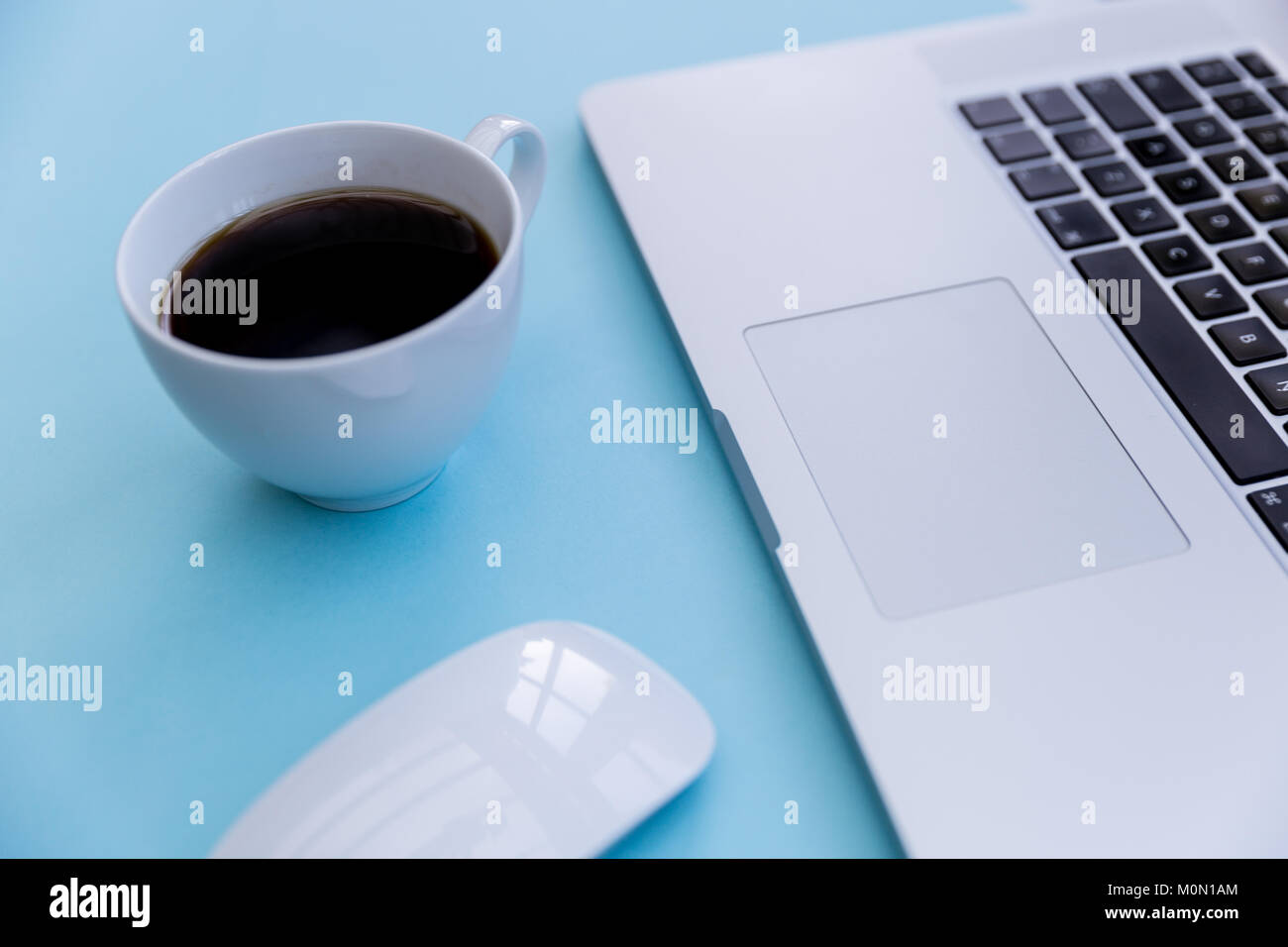 Laptop computer keyboard coffee and mouse on bright pastel blue ...