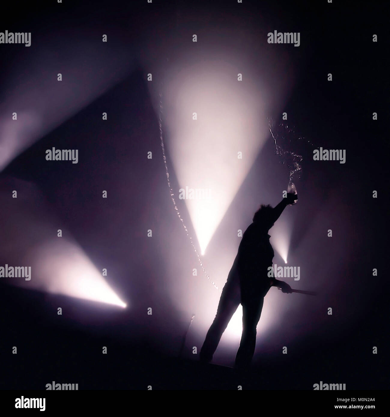 A musician is pouring water over the concert crowd during a live ...