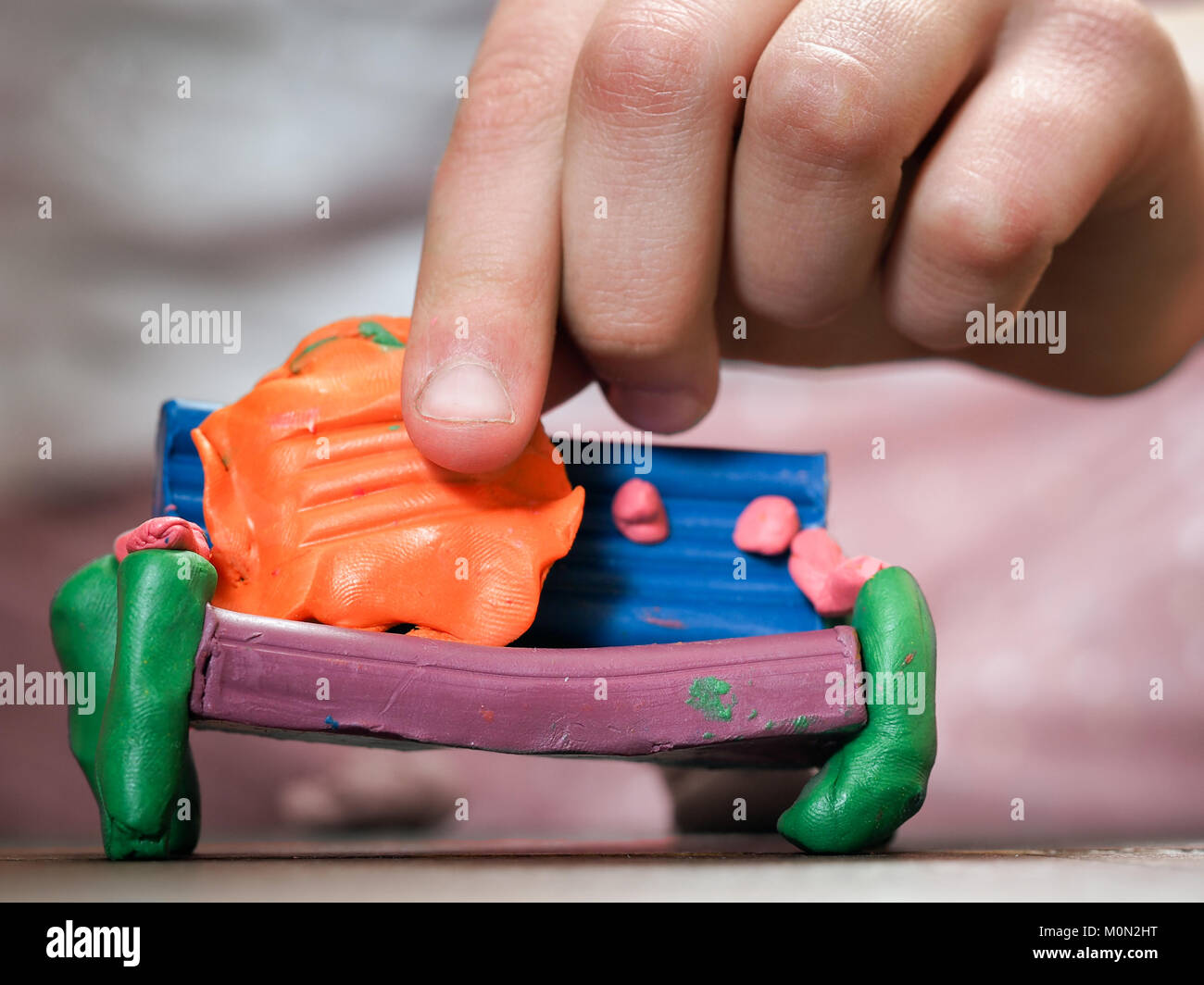 Hands of a small child of play plasticine. Is sculptured the figure of ...