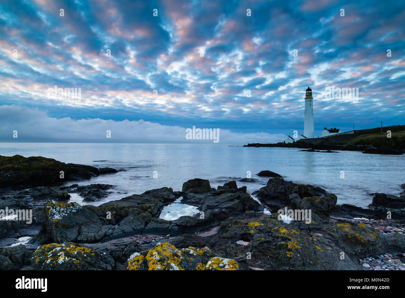 Pink clouds in the sky above Scurdie Ness Lighthouse at sunrise Stock ...