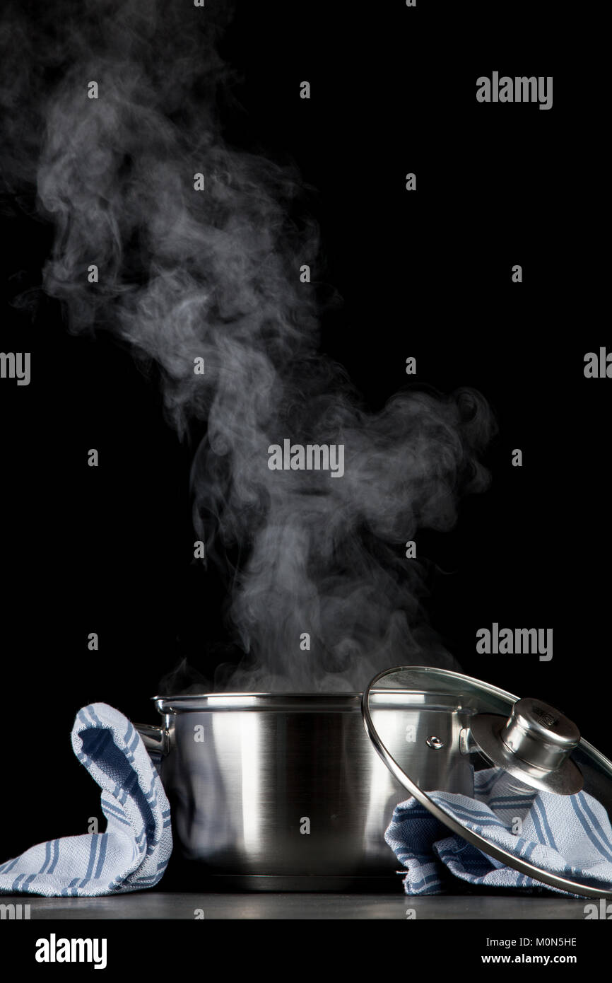 Steaming pot on black background Stock Photo - Alamy