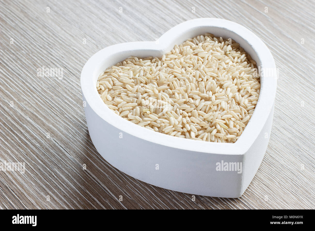 Organic brown rice in heart shaped bowl Stock Photo - Alamy