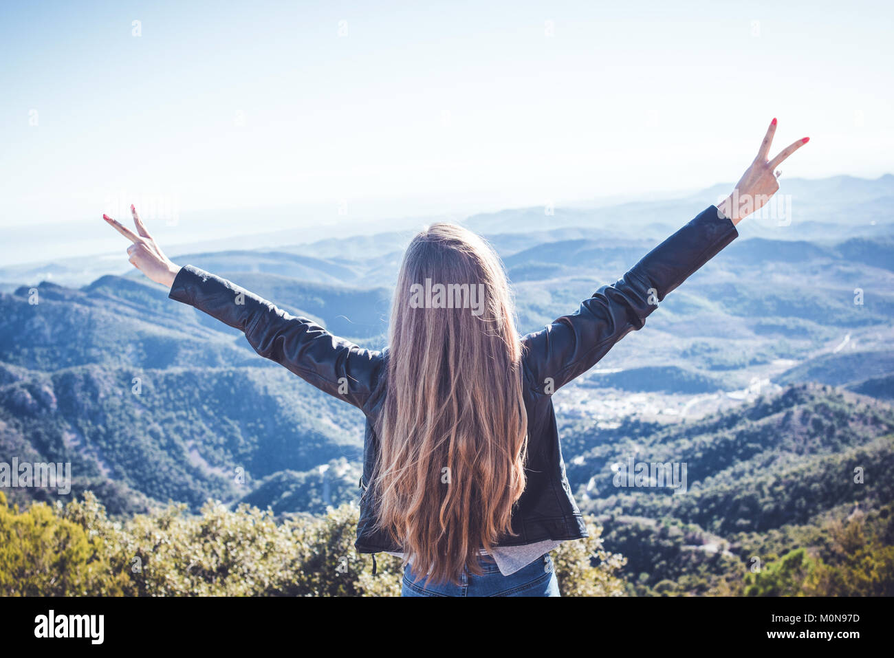 Beautiful women showing peace sign while enjoying mountains landscape ...