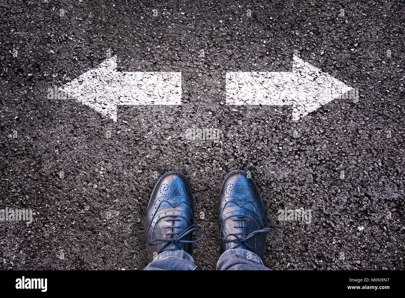 Feet and two arrows painted on an asphalt road Stock Photo - Alamy
