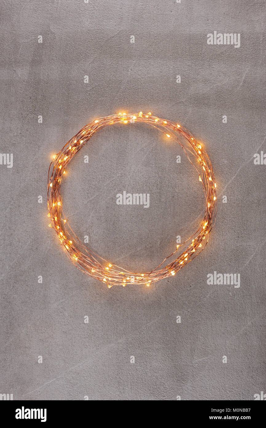 Circle yellow glow led garland on the concrete wall. Background with ...