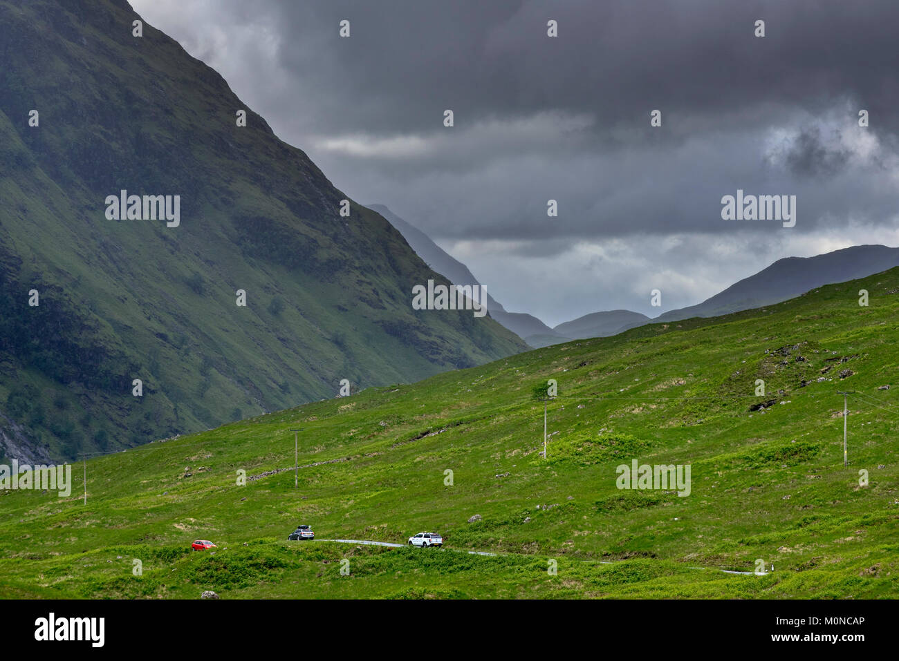 Cars crossing on winding road at passing place in desolate Highland ...