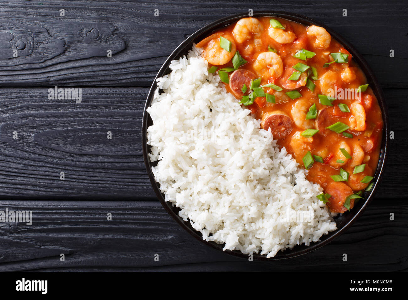 Delicious gumbo with prawns, sausage and rice on a plate on the table ...