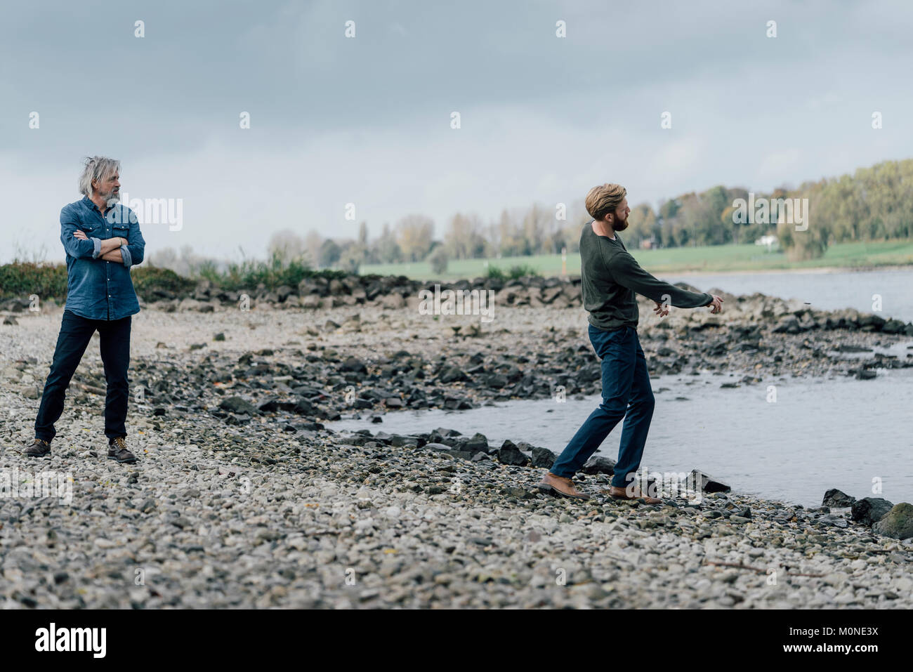 Man throwing pebble water family hi-res stock photography and images ...