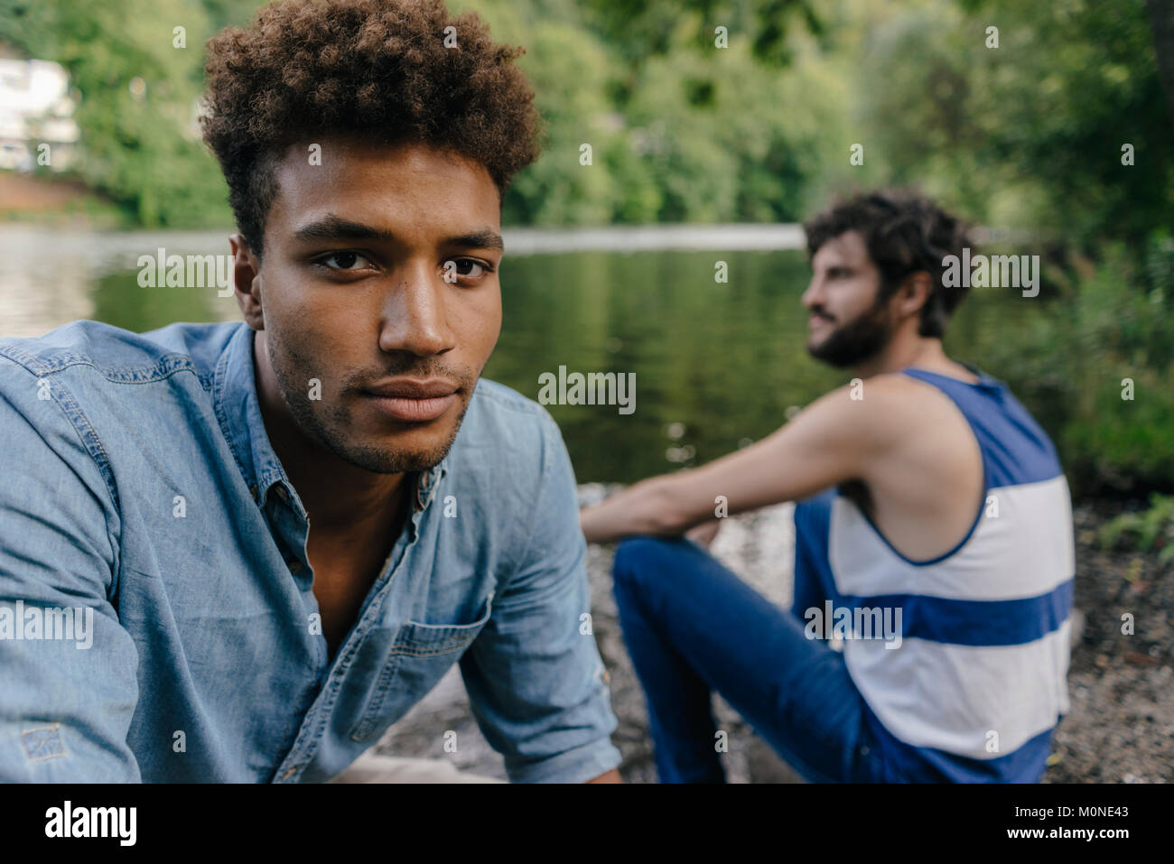 Portrait of young man with friend relaxing at the water Stock Photo - Alamy