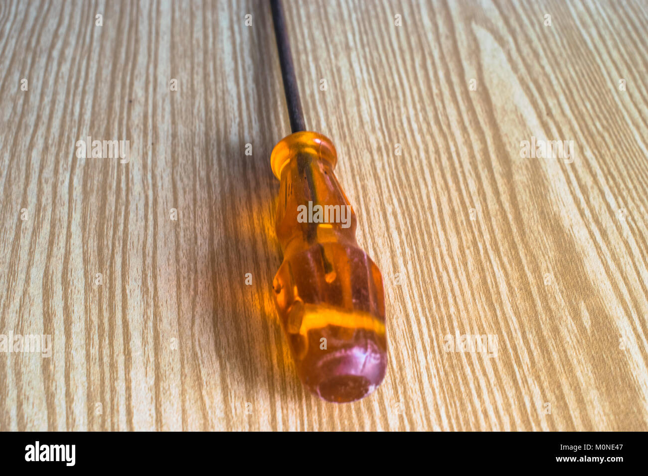 top view of an old and rusty screwdriver kept on a wooden table with ...