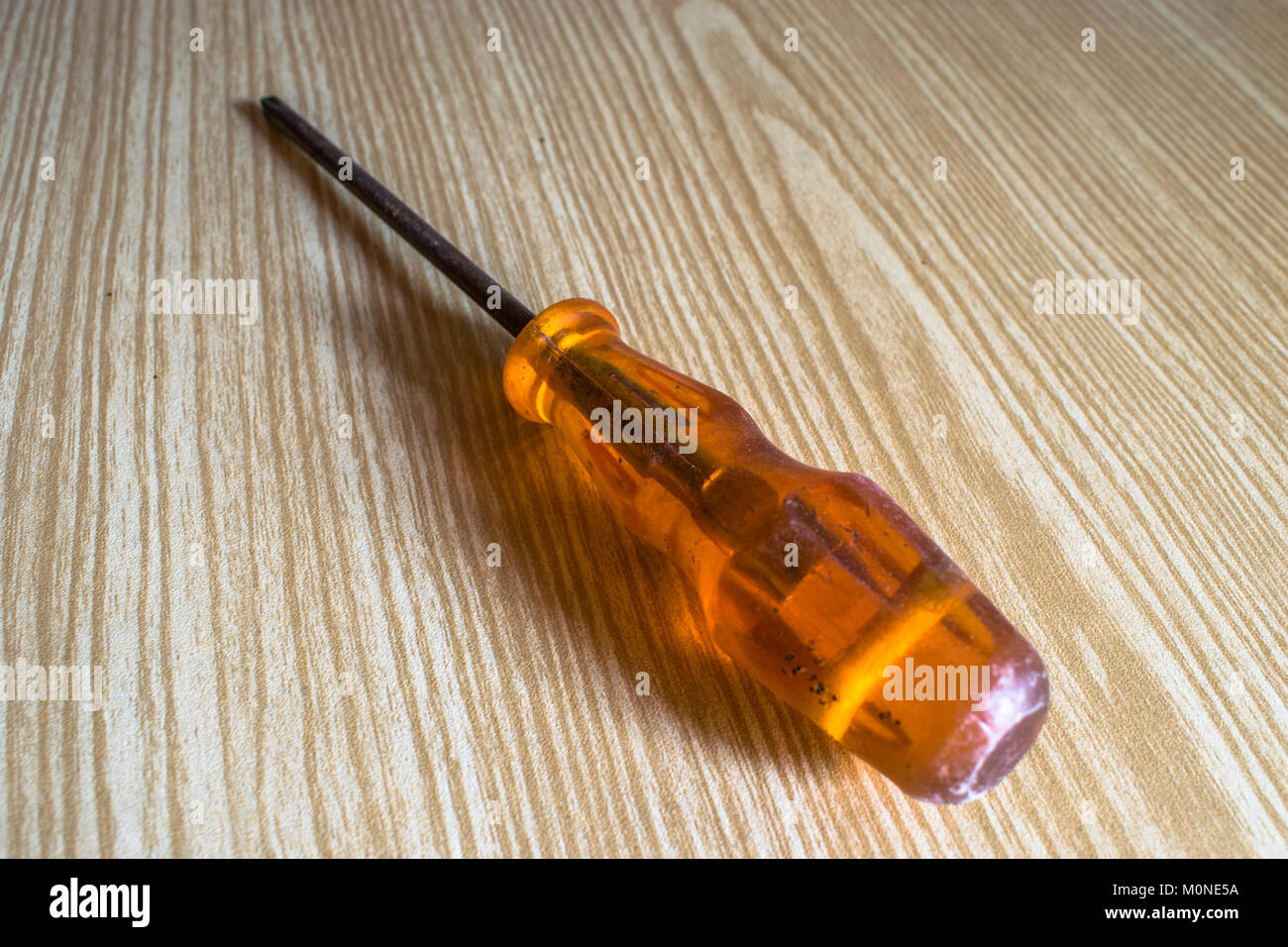 top view of an old and rusty screwdriver kept on a wooden table with ...