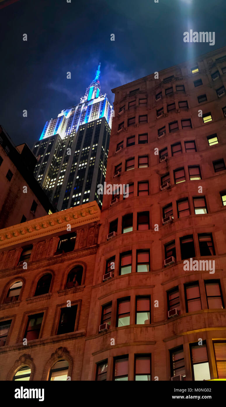 USA, New York, High-rise buildings and Empire State Building at night ...