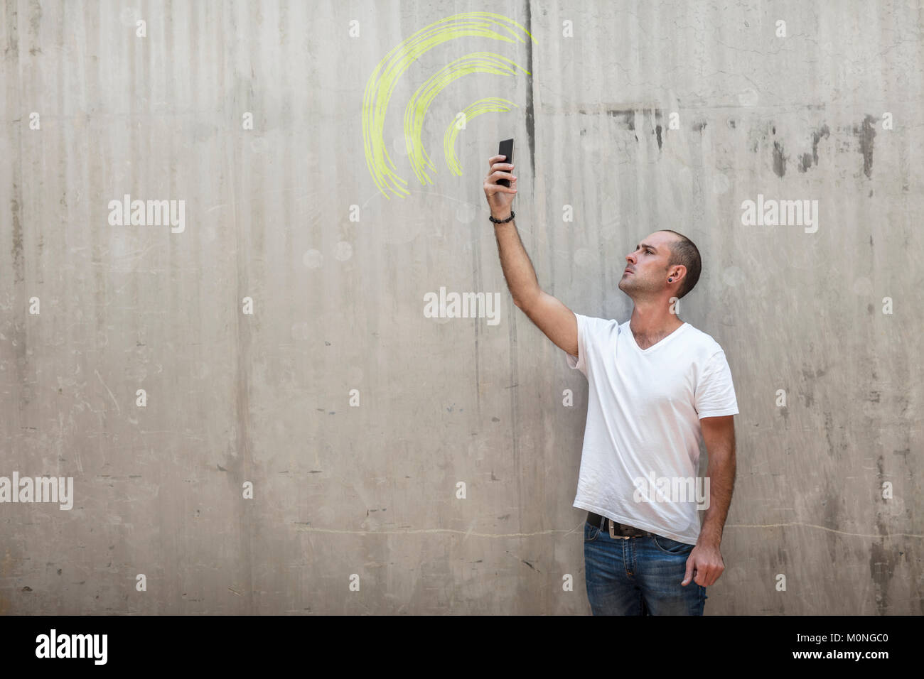 Man holding up phone looking for signal with wifi sign drawn in yellow ...