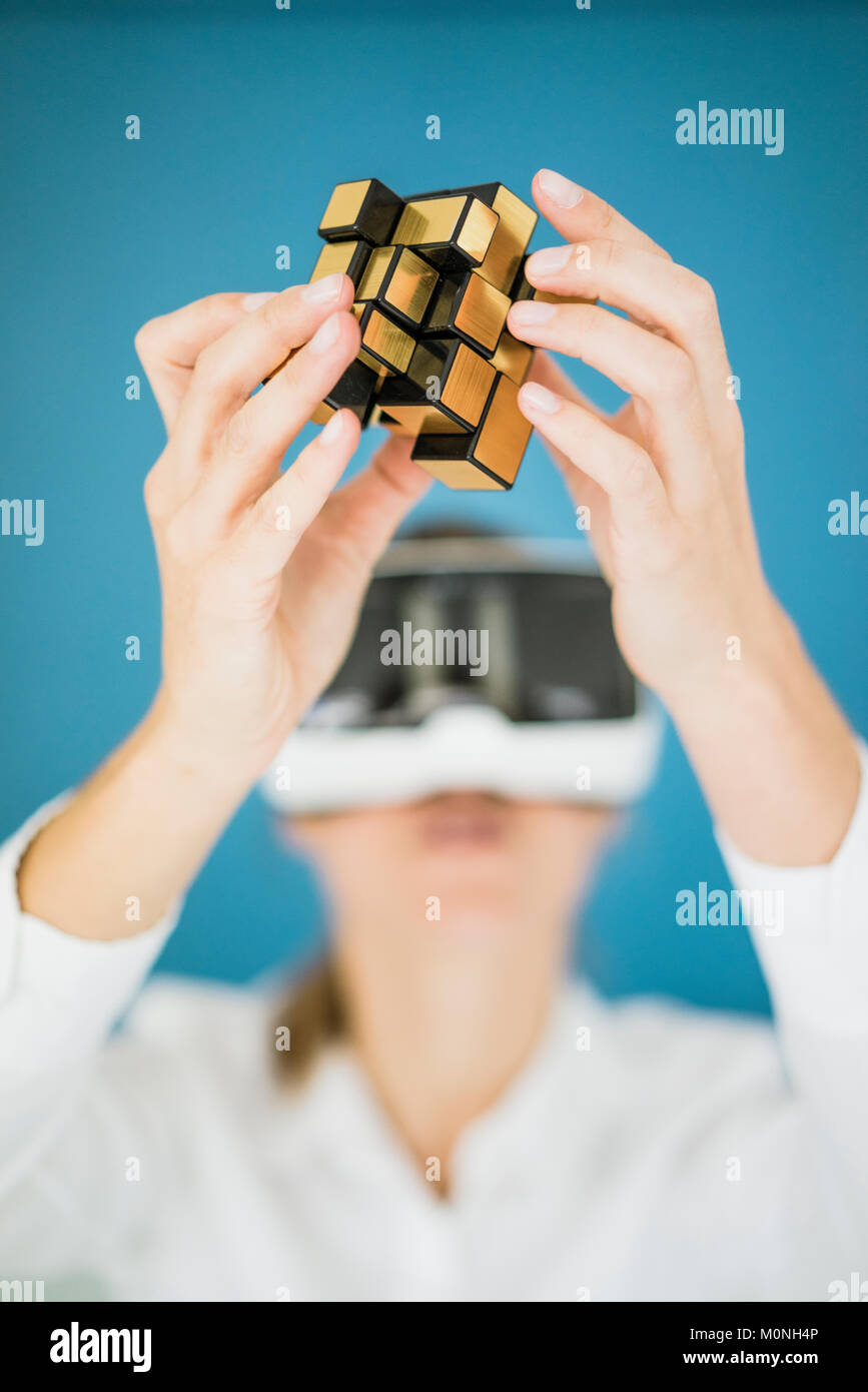 Businesswoman wearing VR glasses holding cubical structure Stock Photo ...