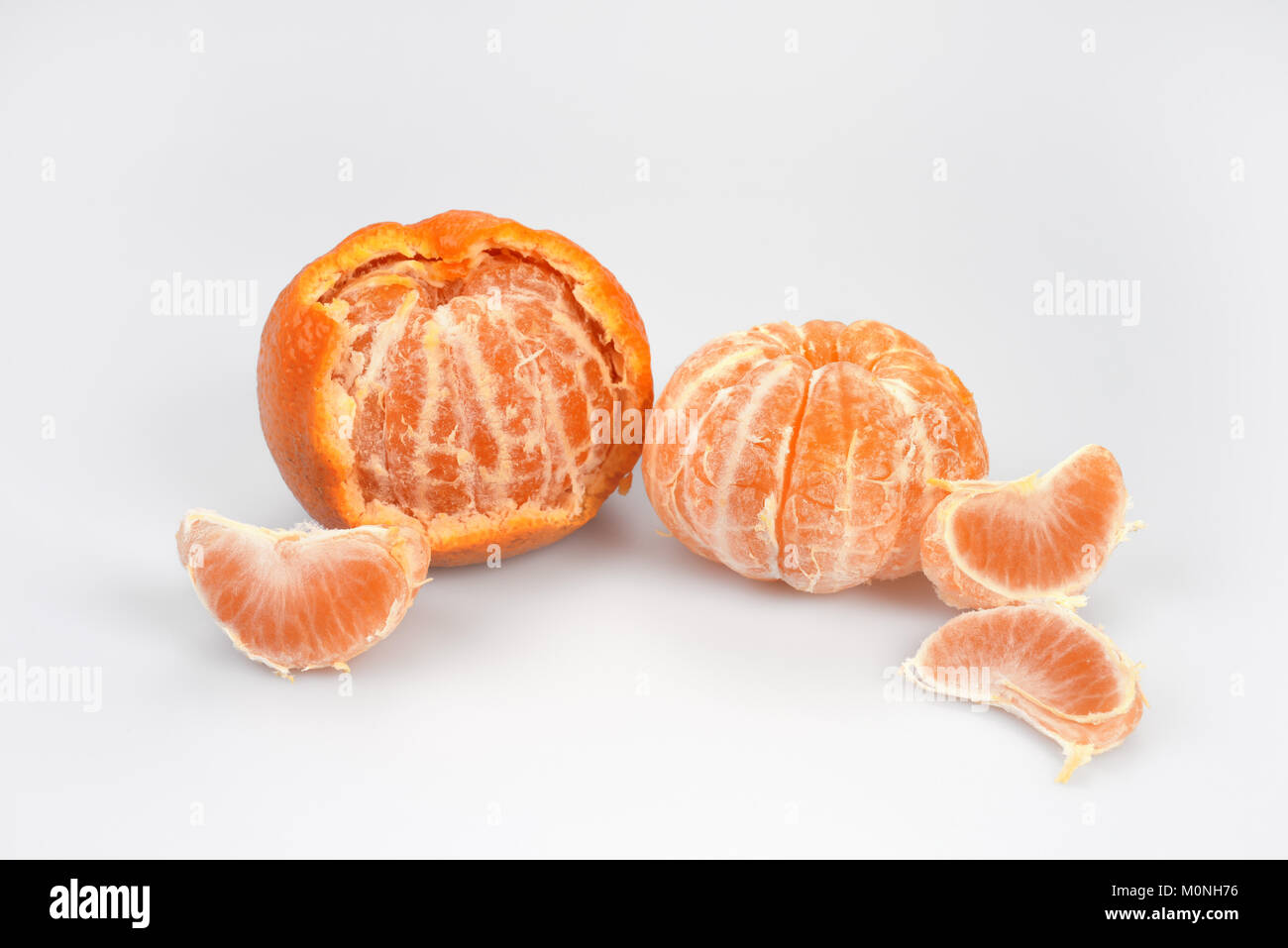 Two mandarins, peeled and peeled on a white background Stock Photo - Alamy
