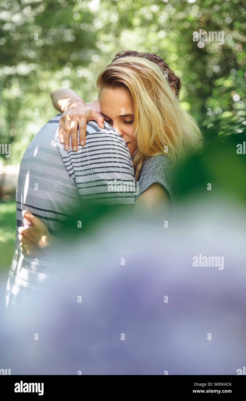 Romantic couple hugging behind an unfocused bouquet of flowers Stock ...