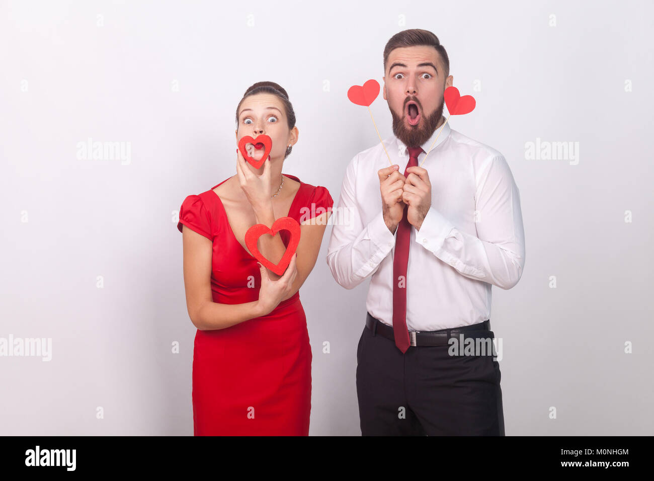 Expressive funny couple holding decorative sign love, heart symbol ...