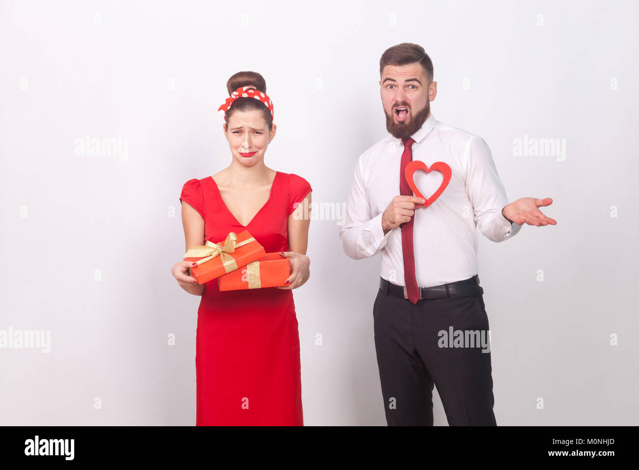 Disappointment. Woman holding gift box and cry, man confused. Indoor ...