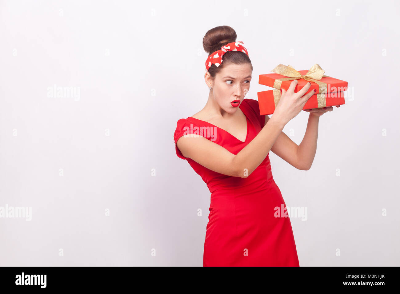 Cunning woman, looking inside gift box . Indoor, studio shot, isolated ...