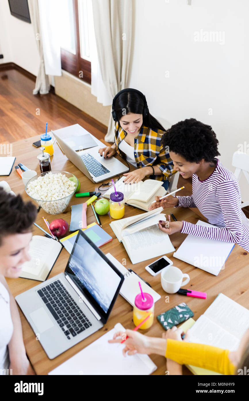 Group of female students working together at table at home Stock Photo ...