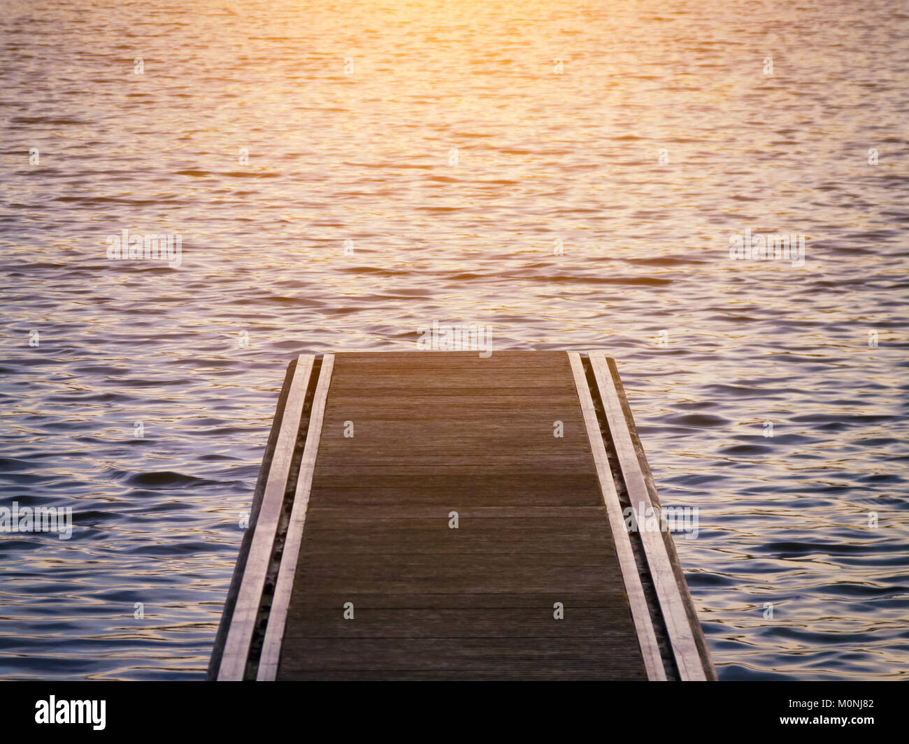 Wooden pier leading into lake Stock Photo - Alamy