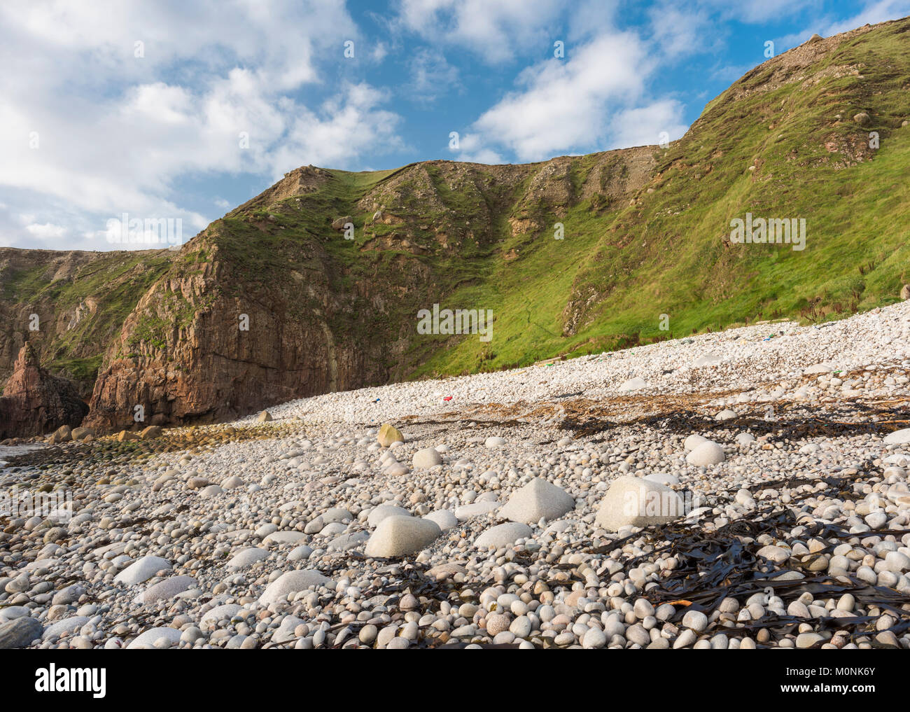 Cliff and shingle beach in a cove at Bloody Foreland, at the north-west ...