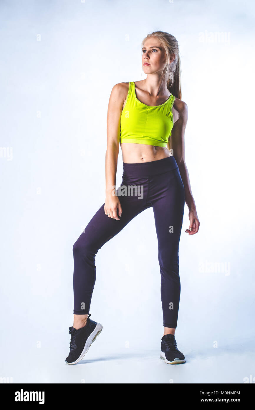 Beautiful female fitness model doing stretches and dancing in a studio ...