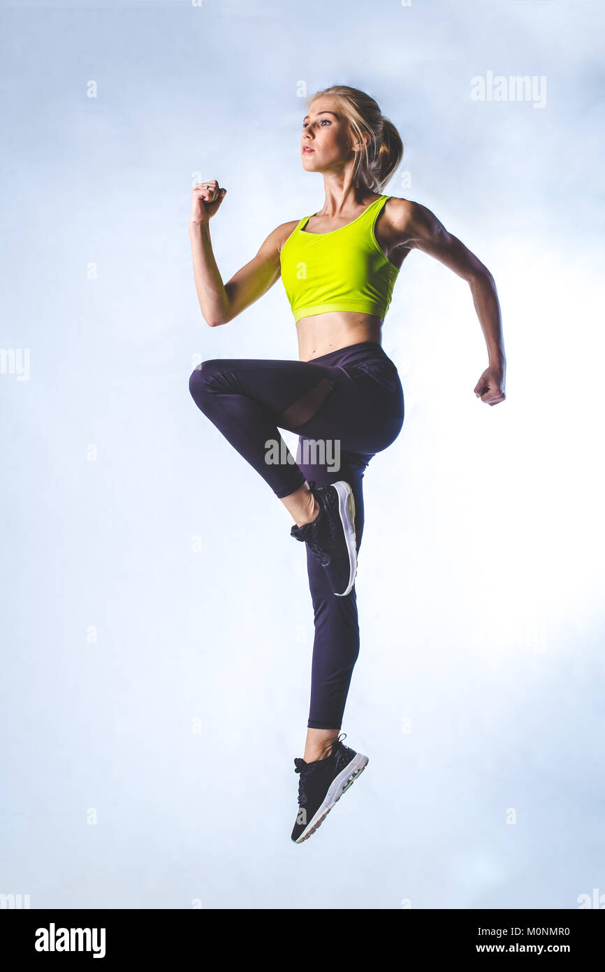 Beautiful female fitness model doing stretches and dancing in a studio ...