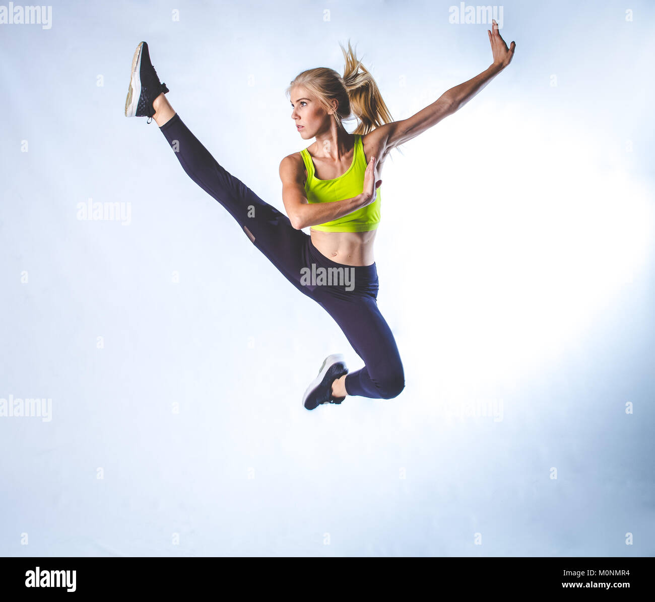 Beautiful female fitness model doing stretches and dancing in a studio ...