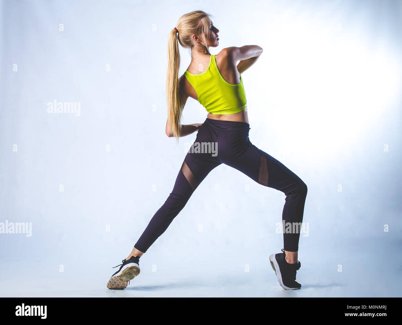 Beautiful female fitness model doing stretches and dancing in a studio ...