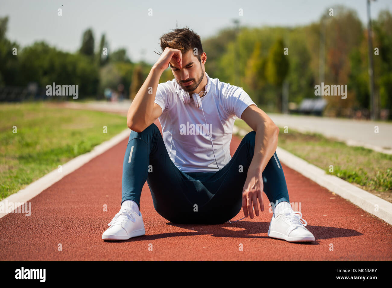 Young man got injured while jogging on sunny day Stock Photo - Alamy